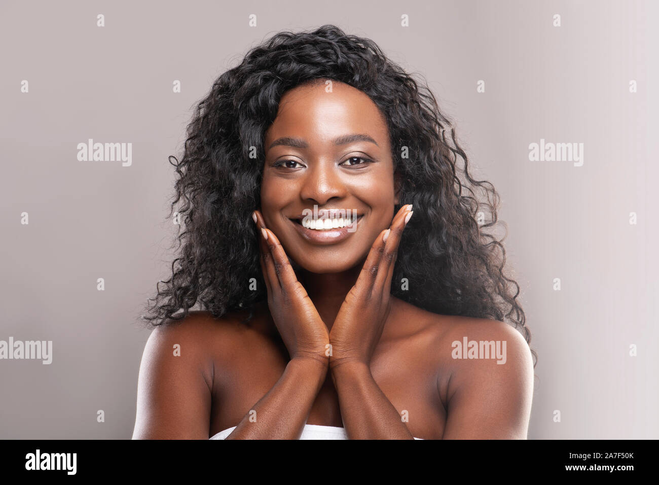 Beautiful african american woman touching her smooth skin on cheeks ...