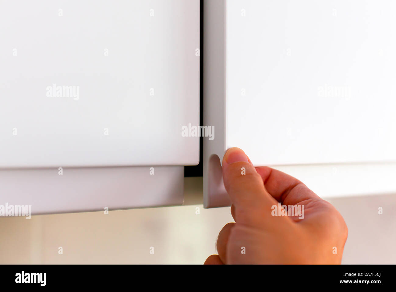 Person hand opening cupboard doors. Close up Stock Photo - Alamy