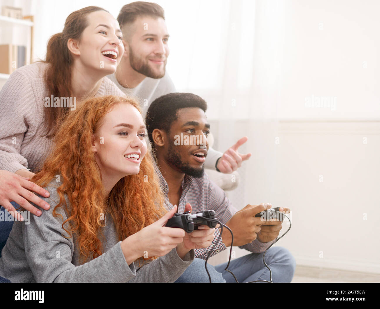 Friends competing in video games, having fun at home Stock Photo - Alamy