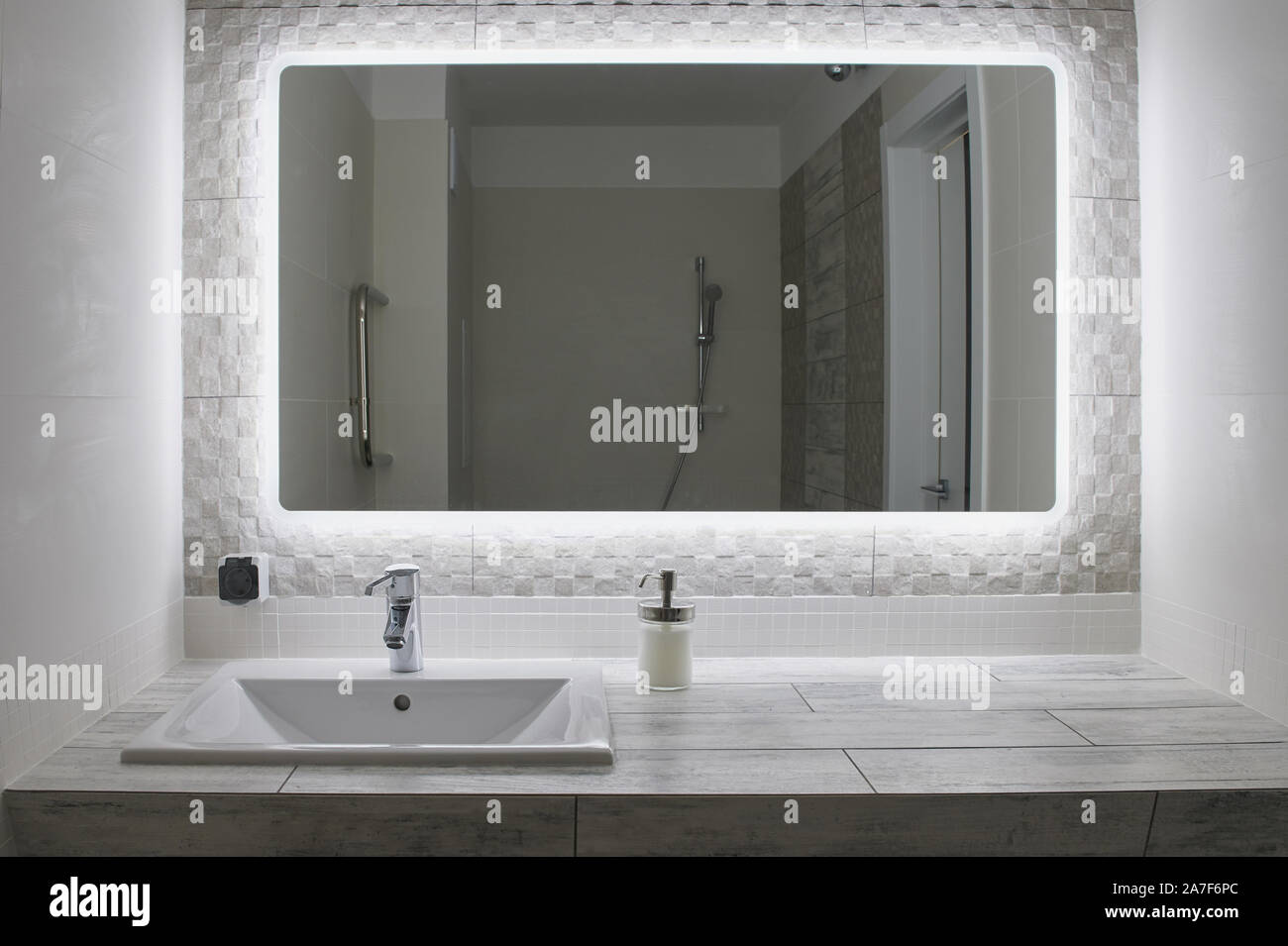 Cozy clean modern bathroom with big mirror and tap Stock Photo - Alamy