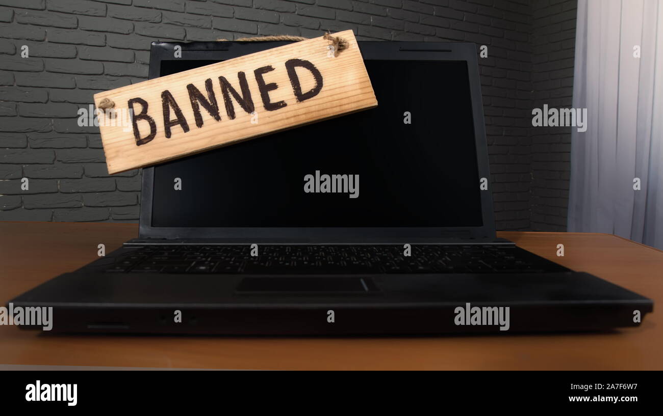 turned off laptop with a wooden sign that says banned Stock Photo - Alamy