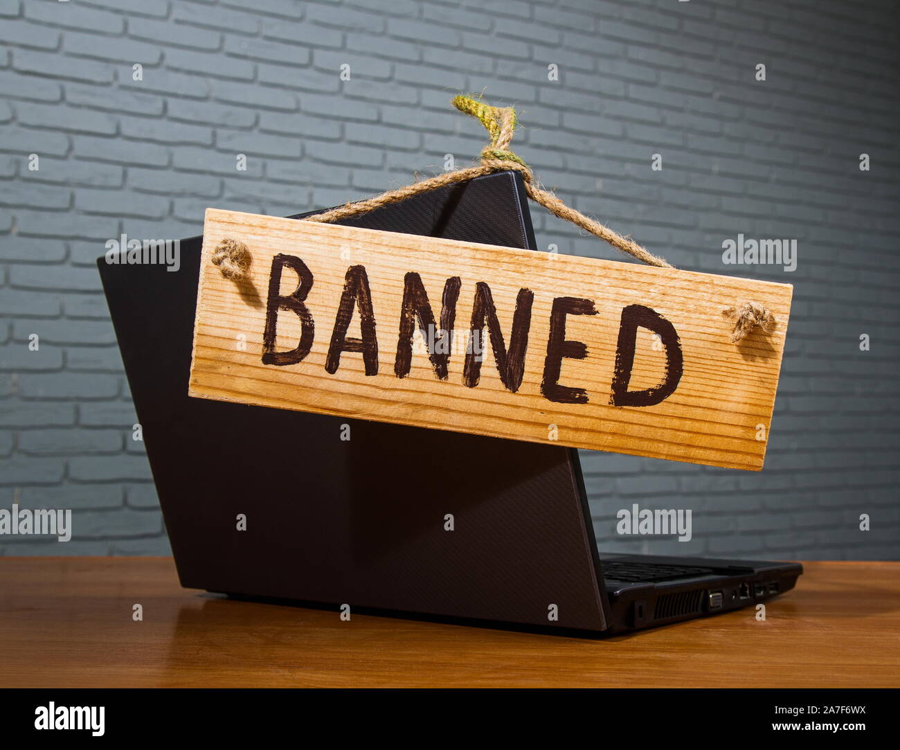 turned off laptop with a wooden sign that says banned Stock Photo - Alamy