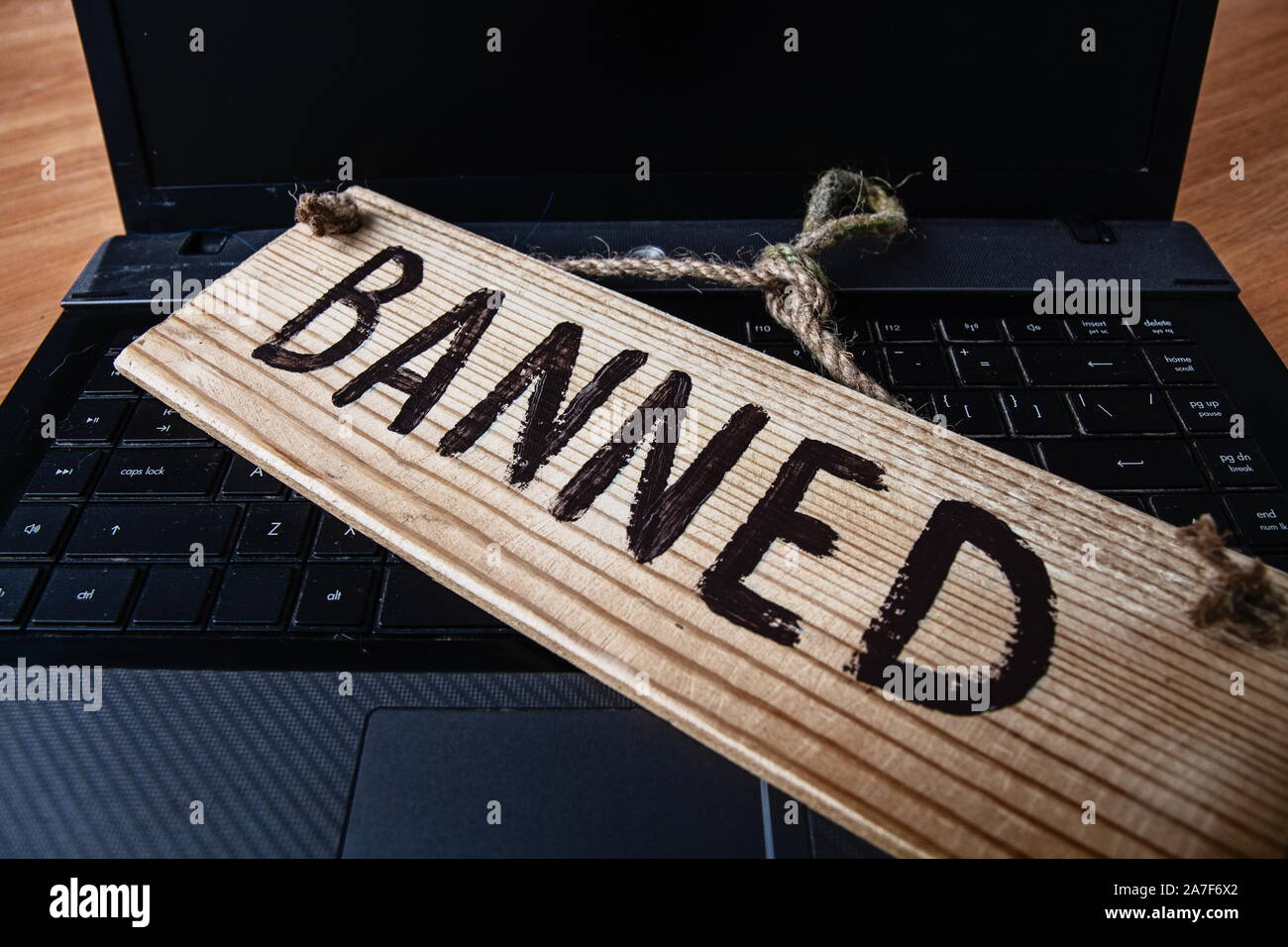 turned off laptop with a wooden sign that says banned Stock Photo - Alamy