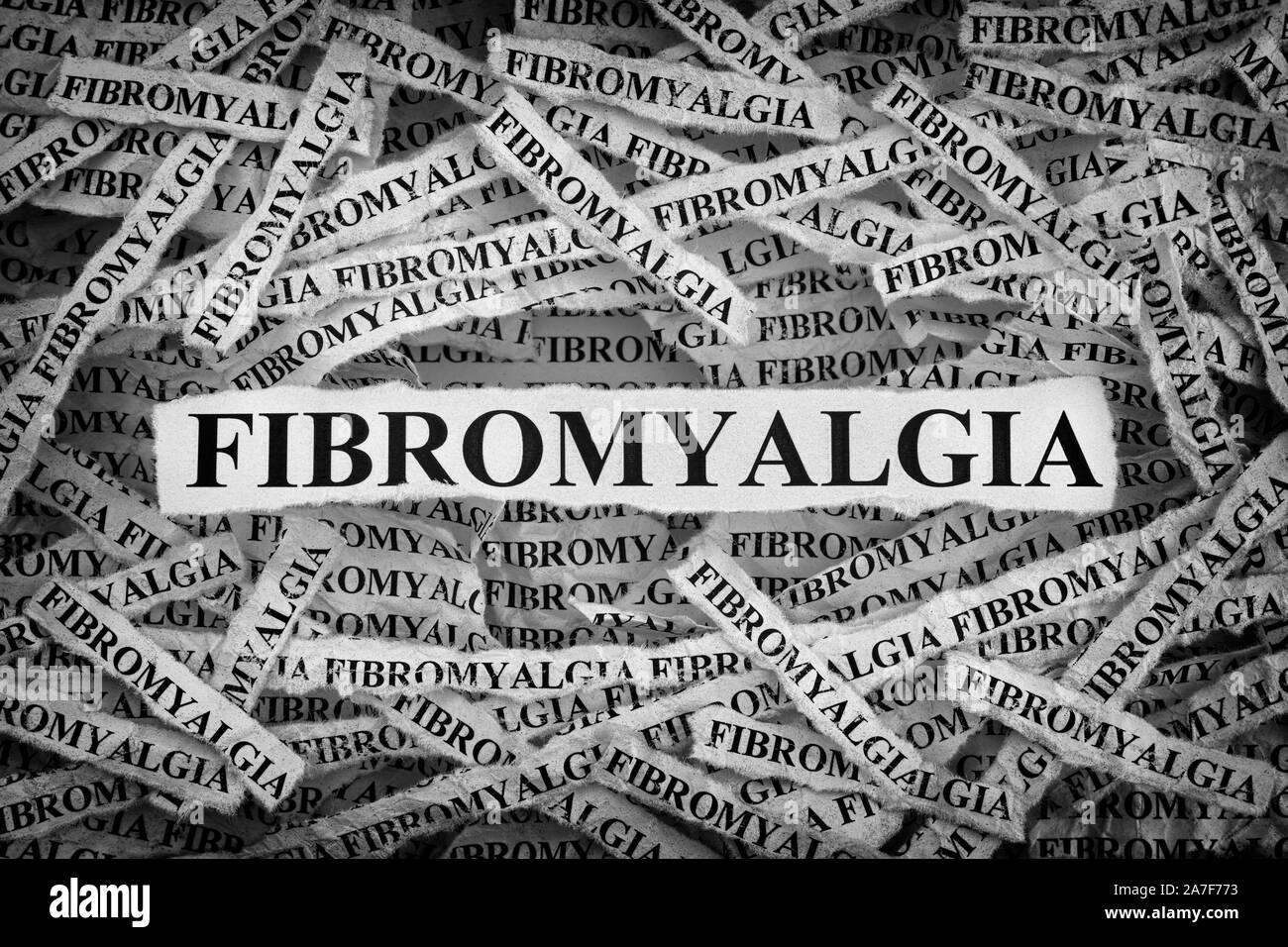 Fibromyalgia. Torn pieces of paper with the word Fibromyalgia. Concept ...