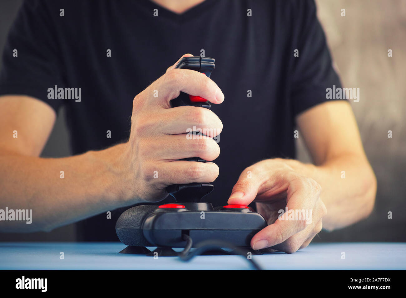 Young man playing video game with a retro joystick. Gaming joystick ...