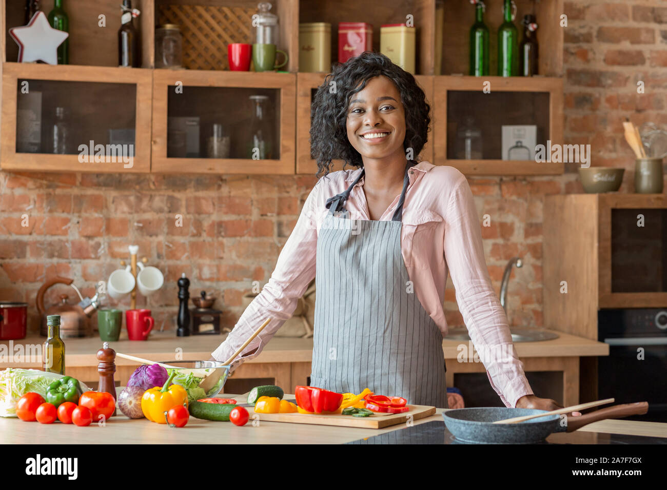 Black woman cooking healthy salad at kitchen, smiling at camera Stock ...