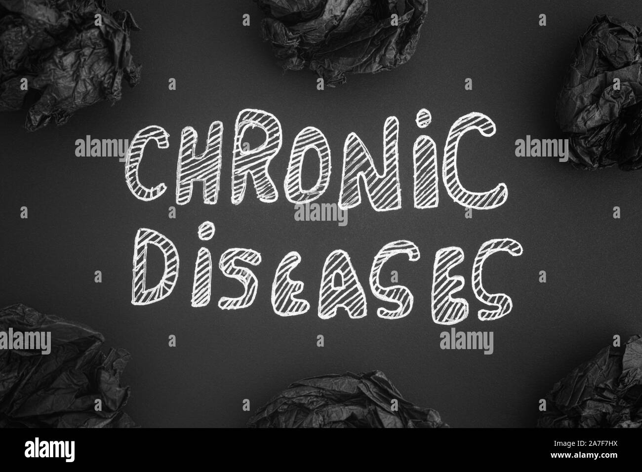 The words Chronic Diseases on a black background with black crumpled ...