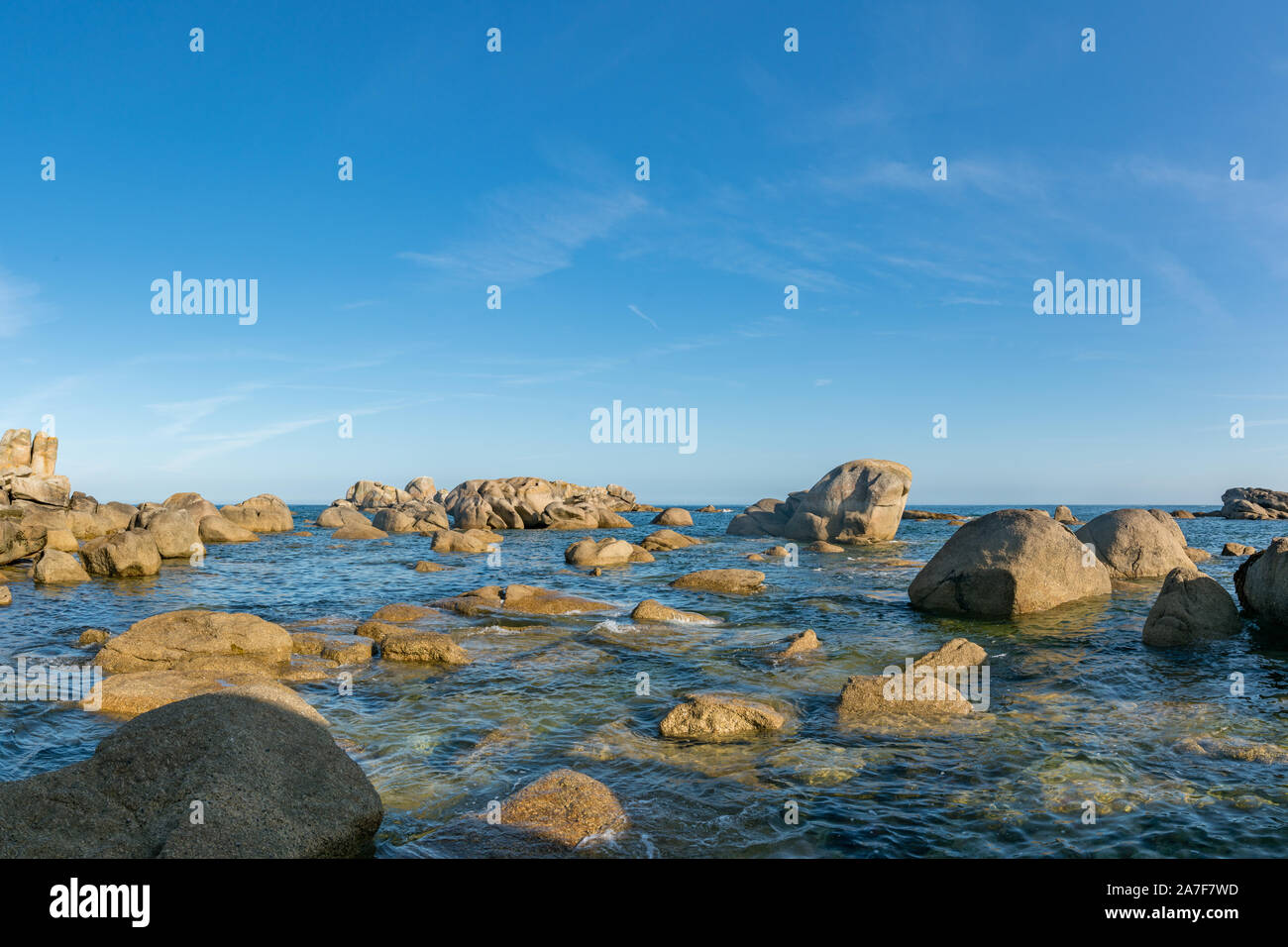 Landscape view of calm ocean and coast with large rocks and granite ...