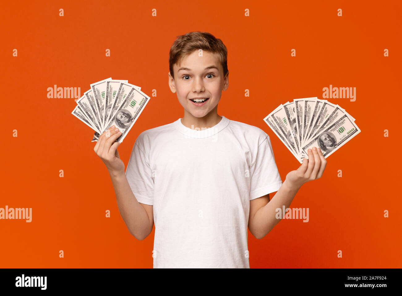 Emotional teenage boy holding fans of dollars Stock Photo - Alamy