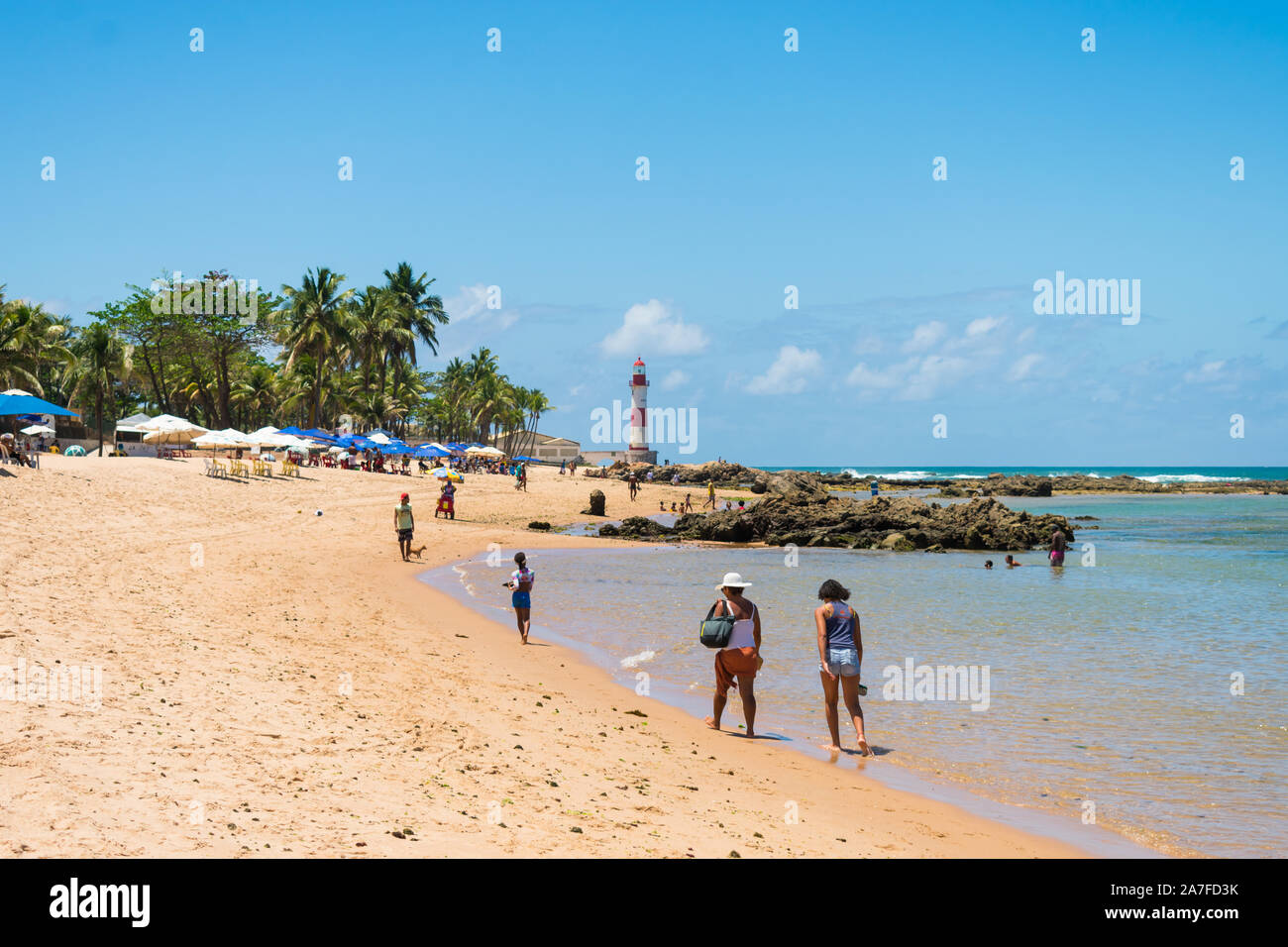People at the beach and a view of Itapua Lighthouse (Farol de Itapua ...