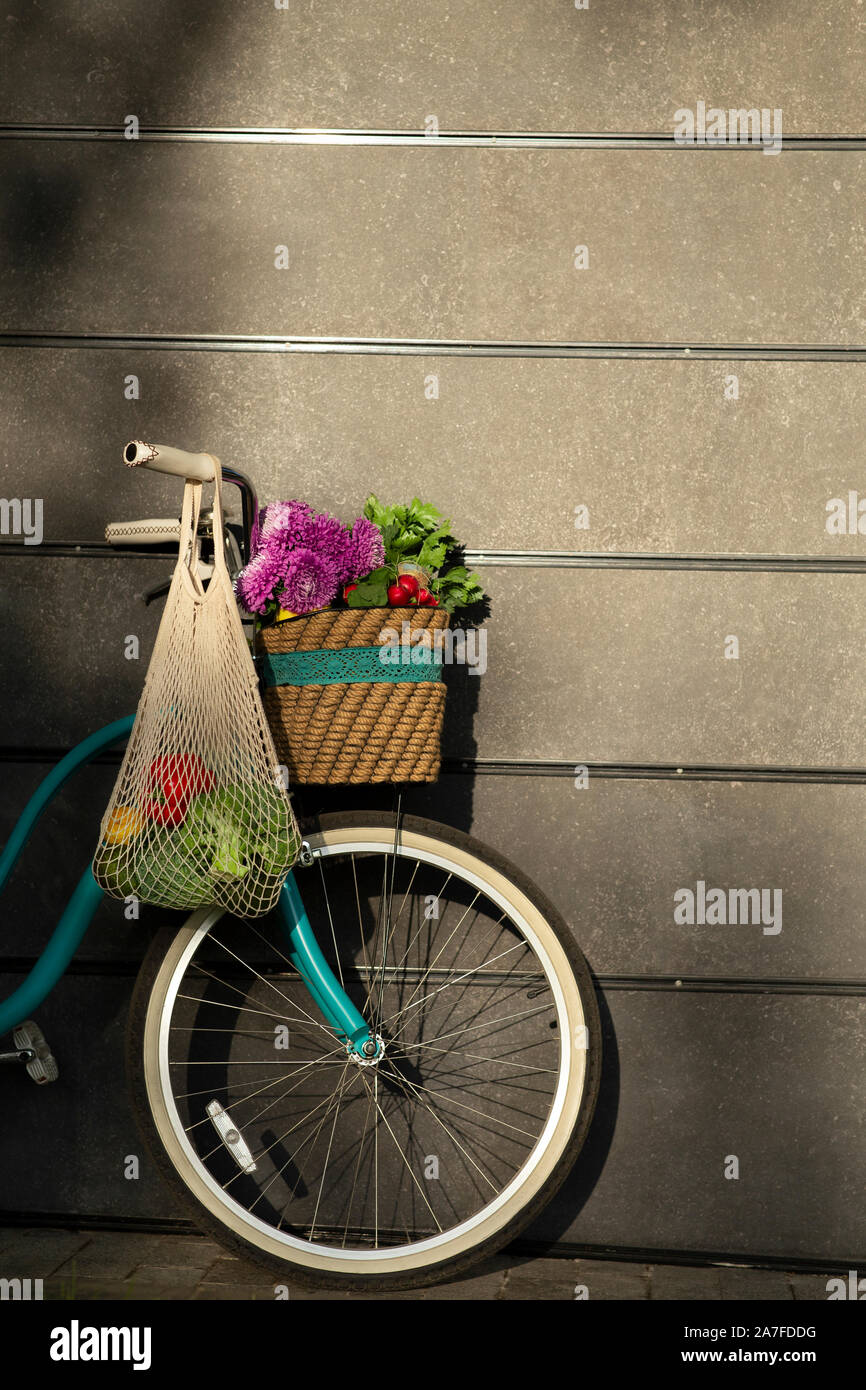 Retro bicycle with wild flowers and eco shopping bag over gray wall ...
