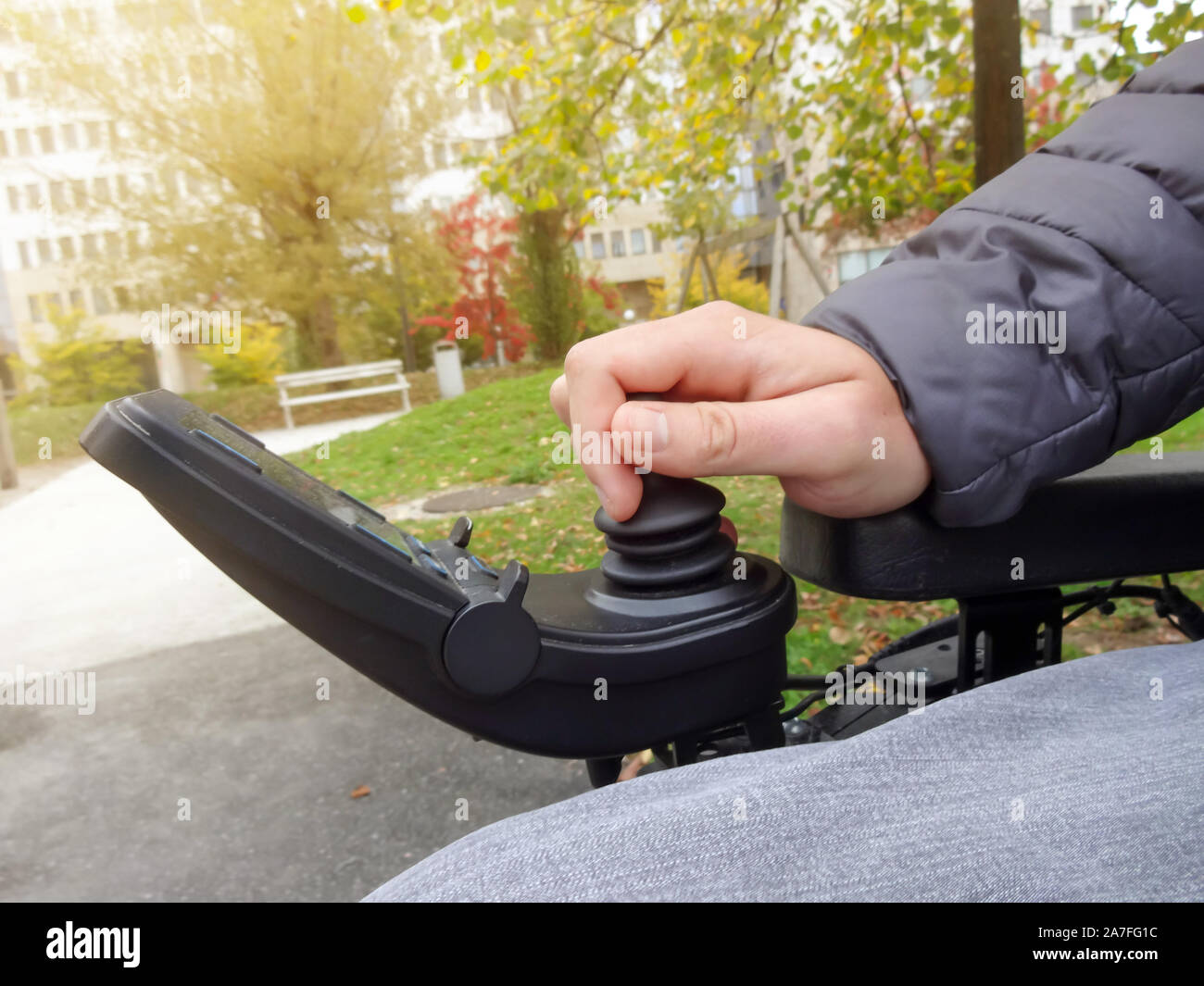 Close up of a disabled person hand driving electric wheelchair using ...