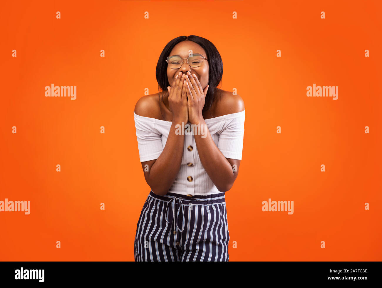 African American Woman Laughing Covering Mouth Standing Over Orange ...