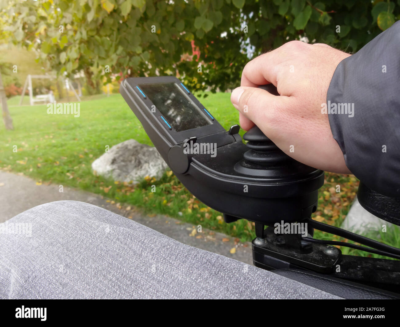 Close up of a disabled person hand driving electric wheelchair using ...