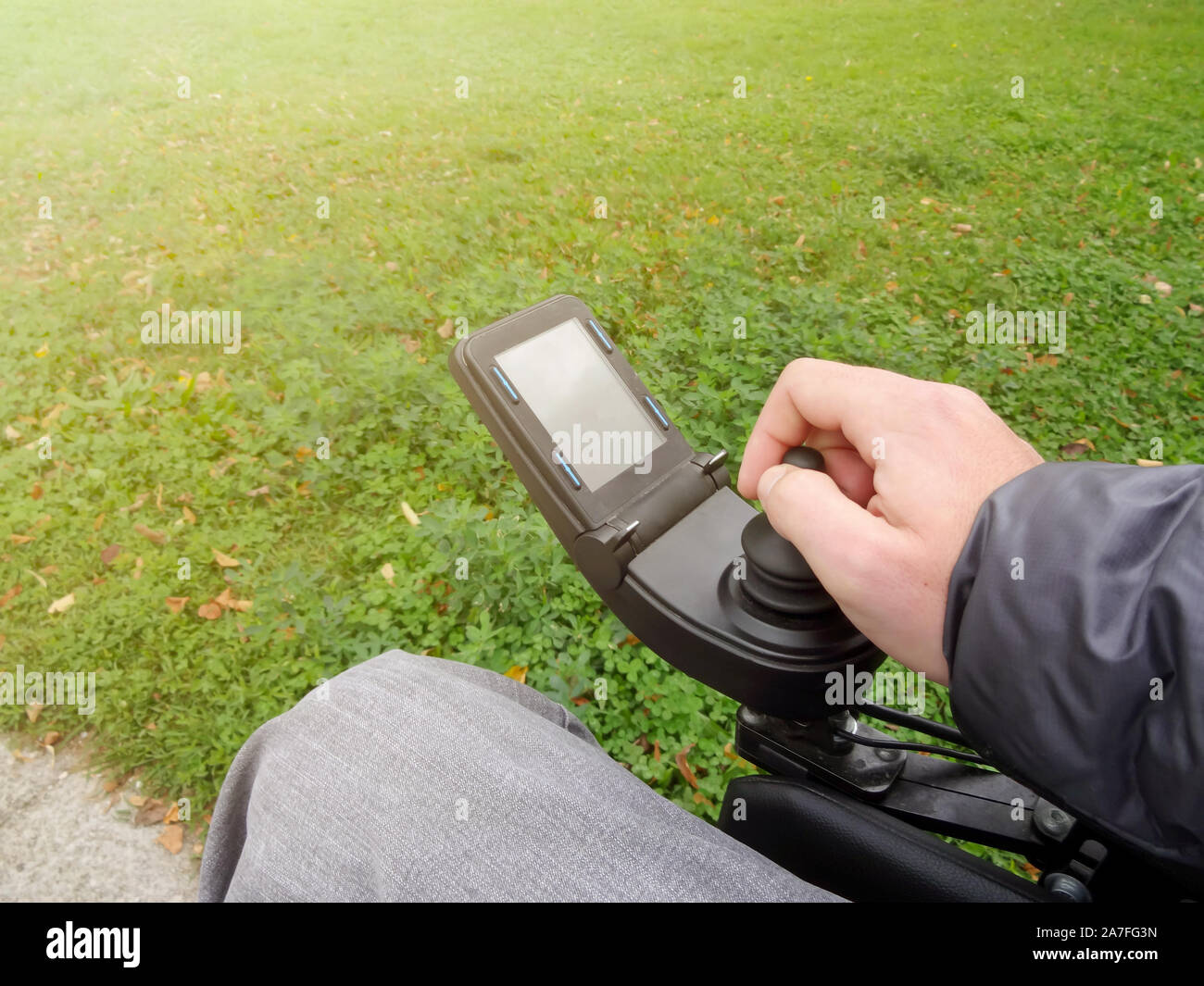 Close up of a disabled person hand driving electric wheelchair using ...