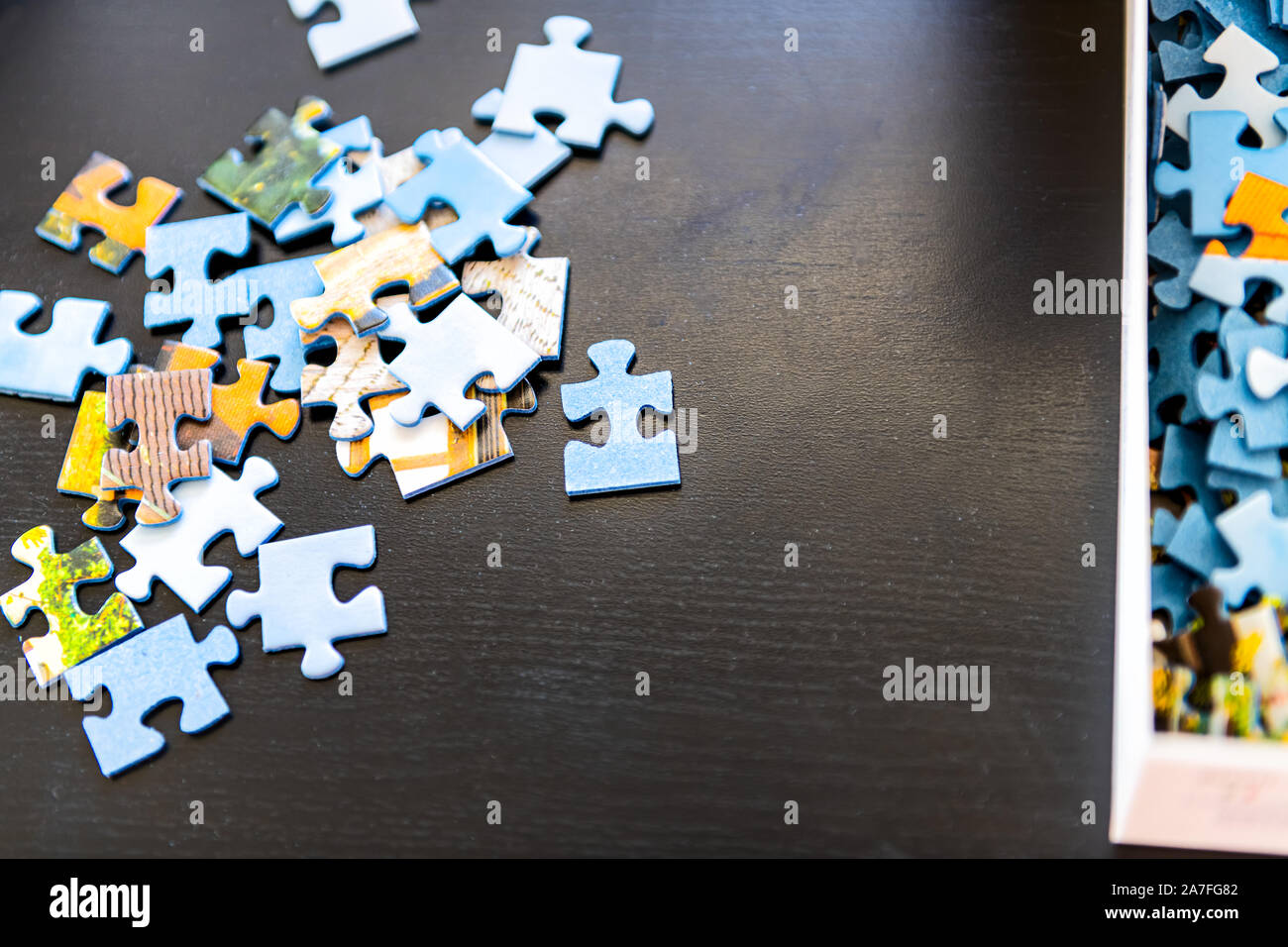 Flat top view of puzzle pieces on table scattered as game in room of ...