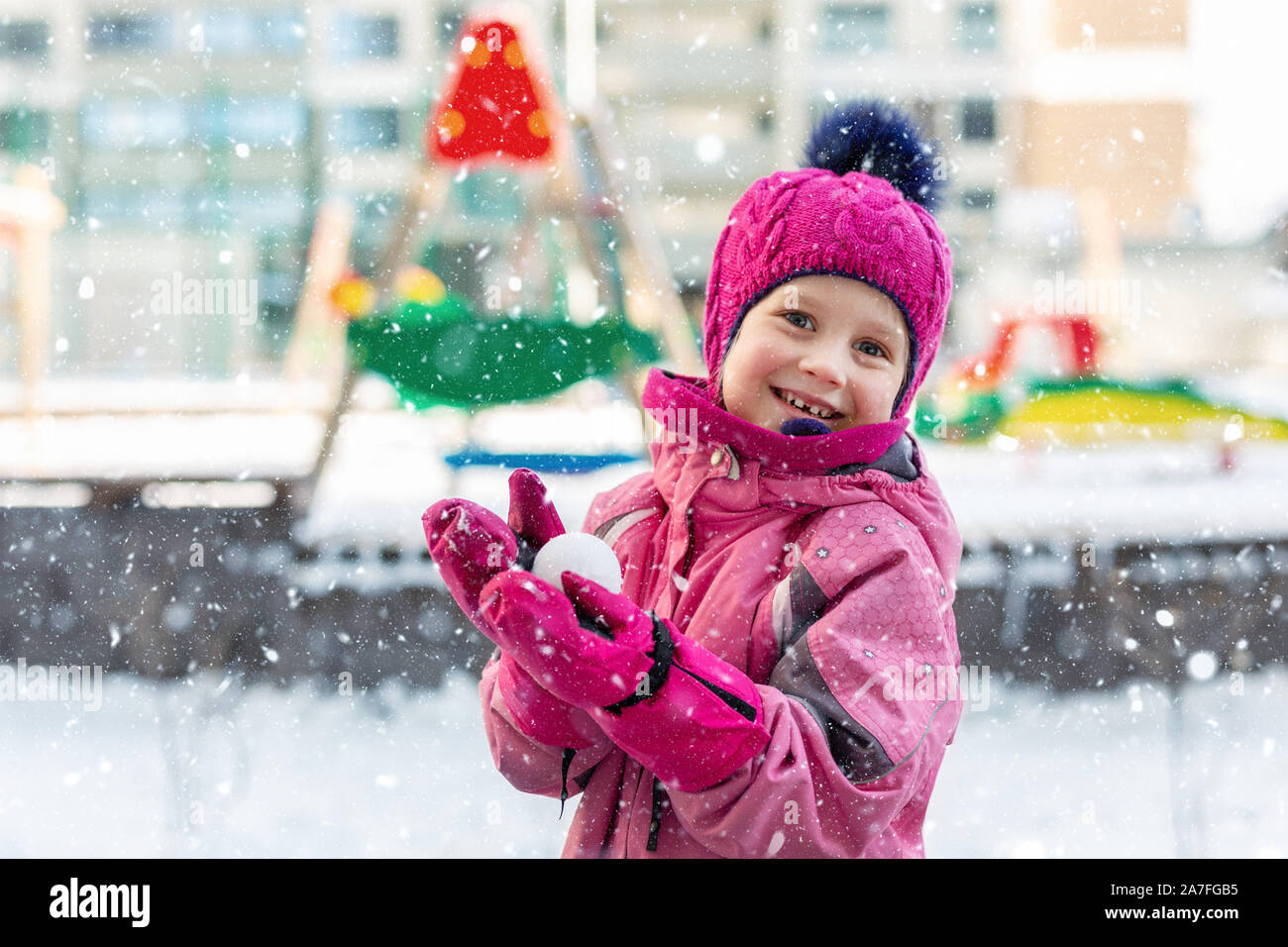 Cute adorable caucasian little girl winter portrait holding snowball in ...