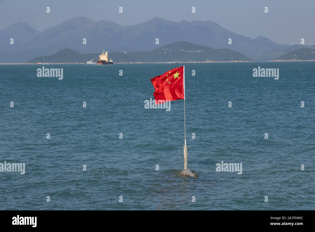The Chinese flag flies from a rock at sea by Lamma Island, Hong Kong ...