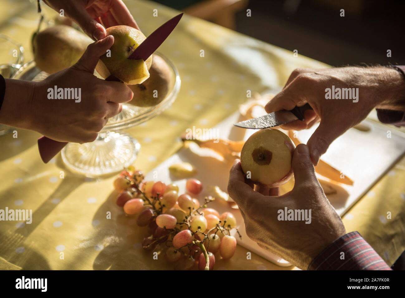 Older woman and man's hand cutting up fruit Stock Photo - Alamy