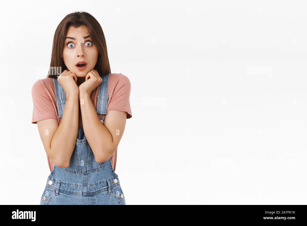 Shocked, scared timid insecure cute girl in dungarees and t-shirt ...