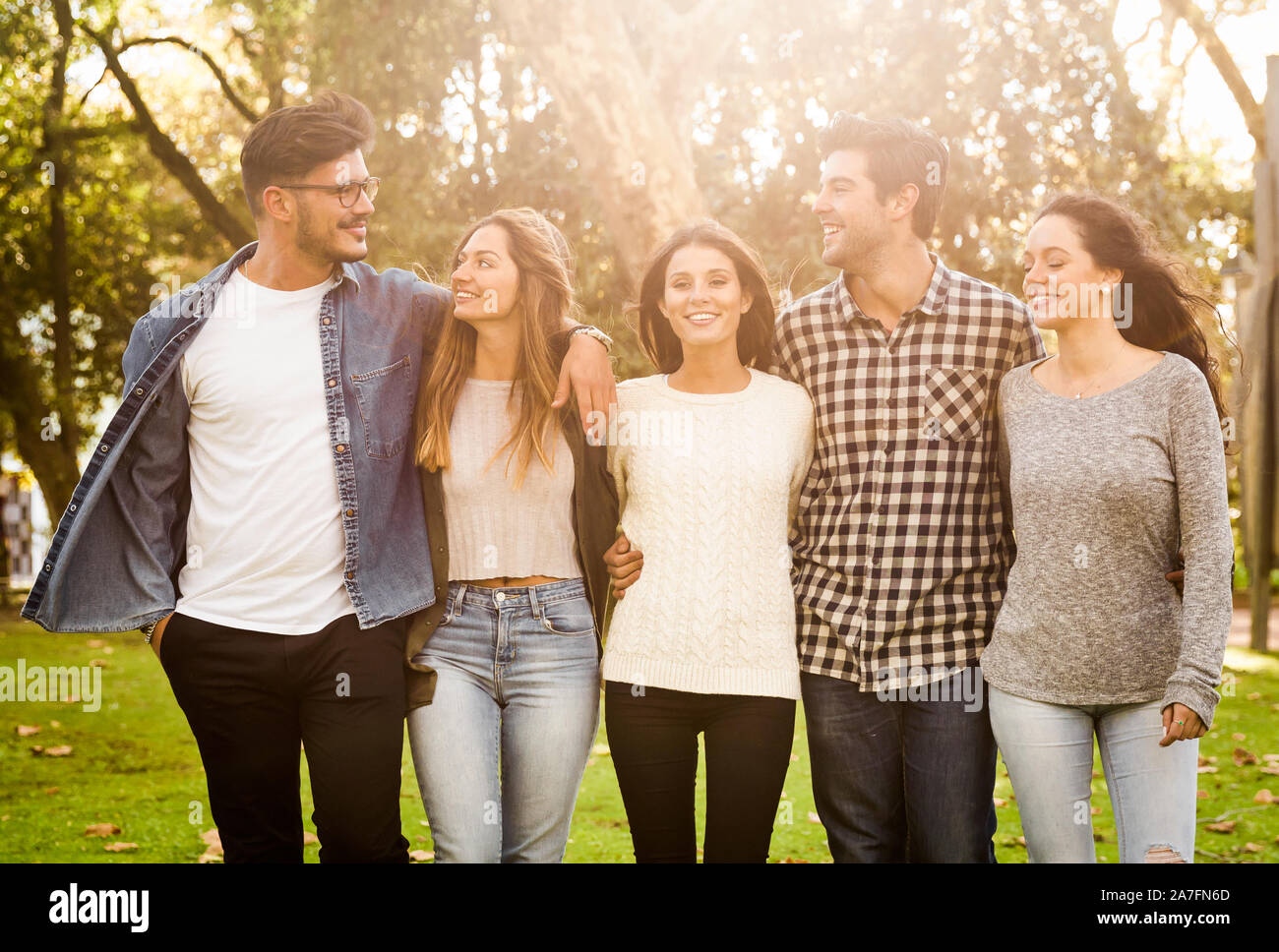 Group of students walking together in the park Stock Photo - Alamy
