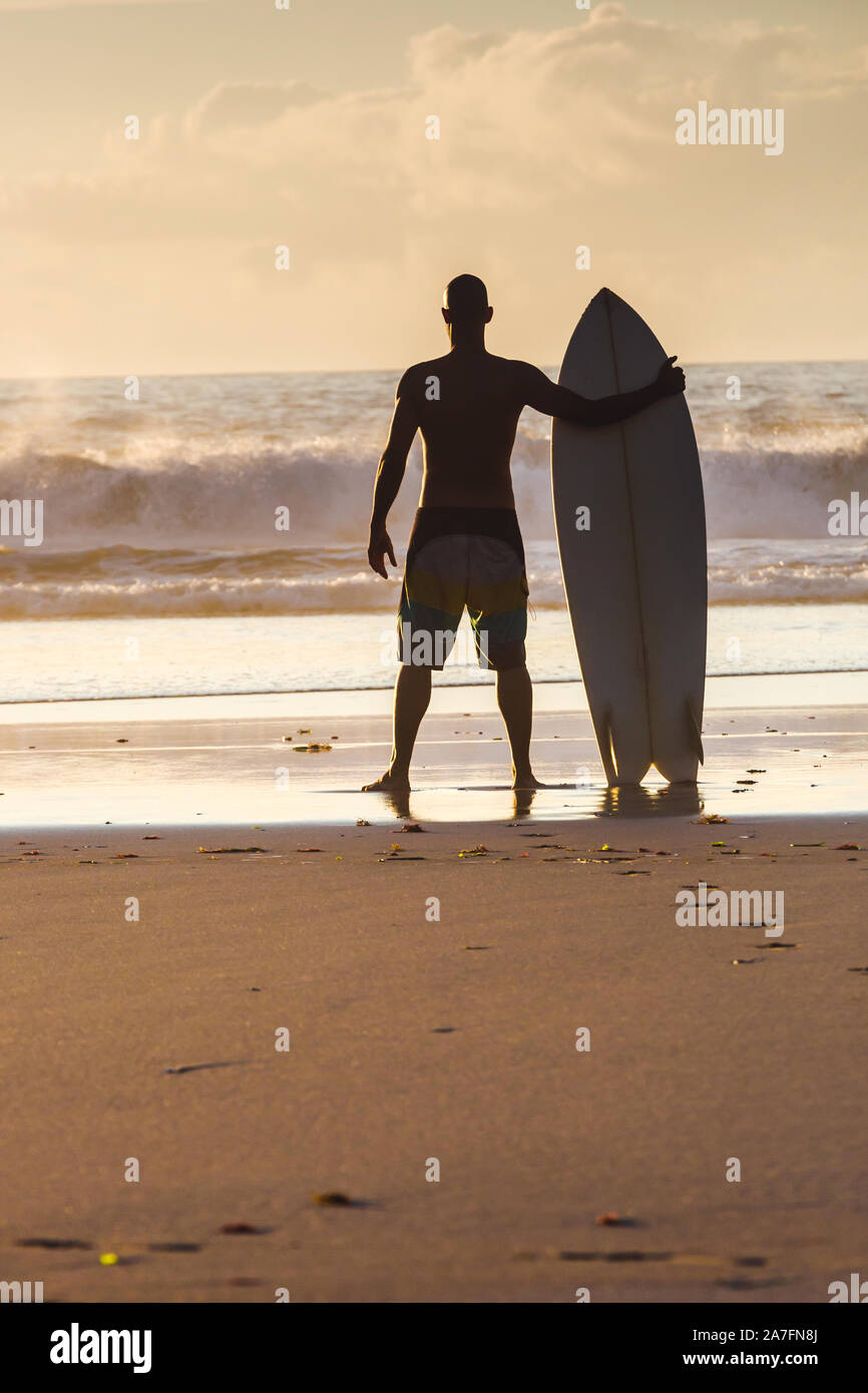 Surfer on the beach holding is surfboard and checking the waves Stock ...