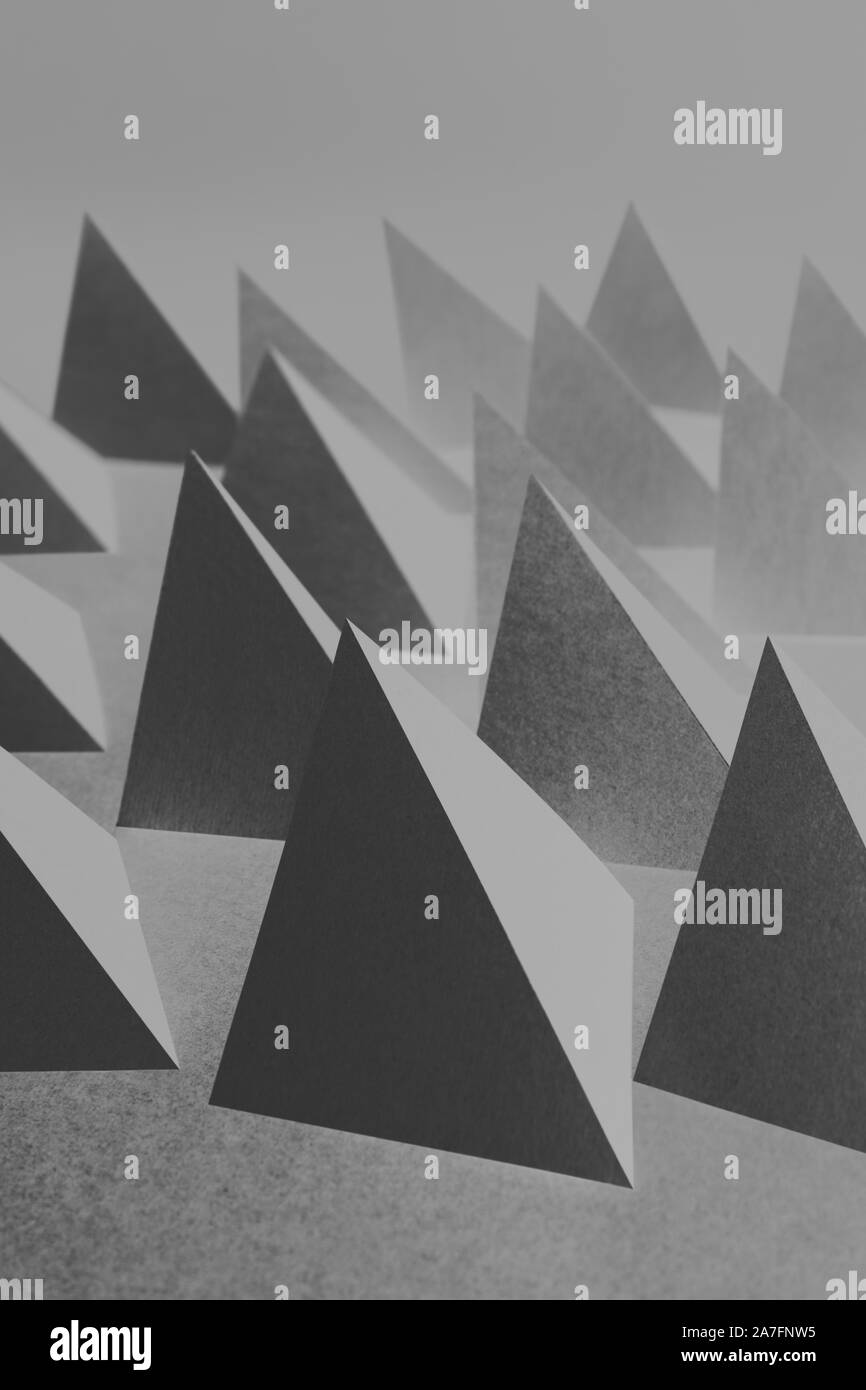 Pyramids of paper, dark abstract background Stock Photo - Alamy