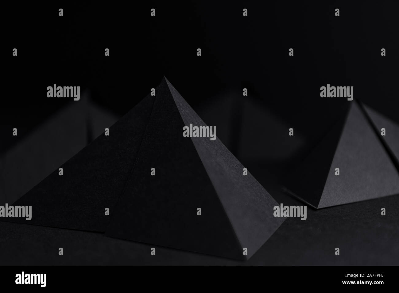 Triangular shapes of paper on dark background, abstract Stock Photo - Alamy
