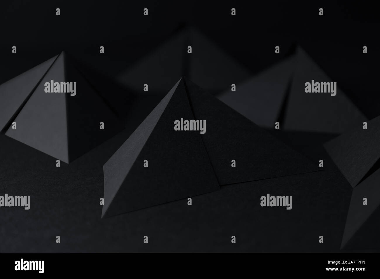 Triangular shapes of paper on dark background, abstract Stock Photo - Alamy