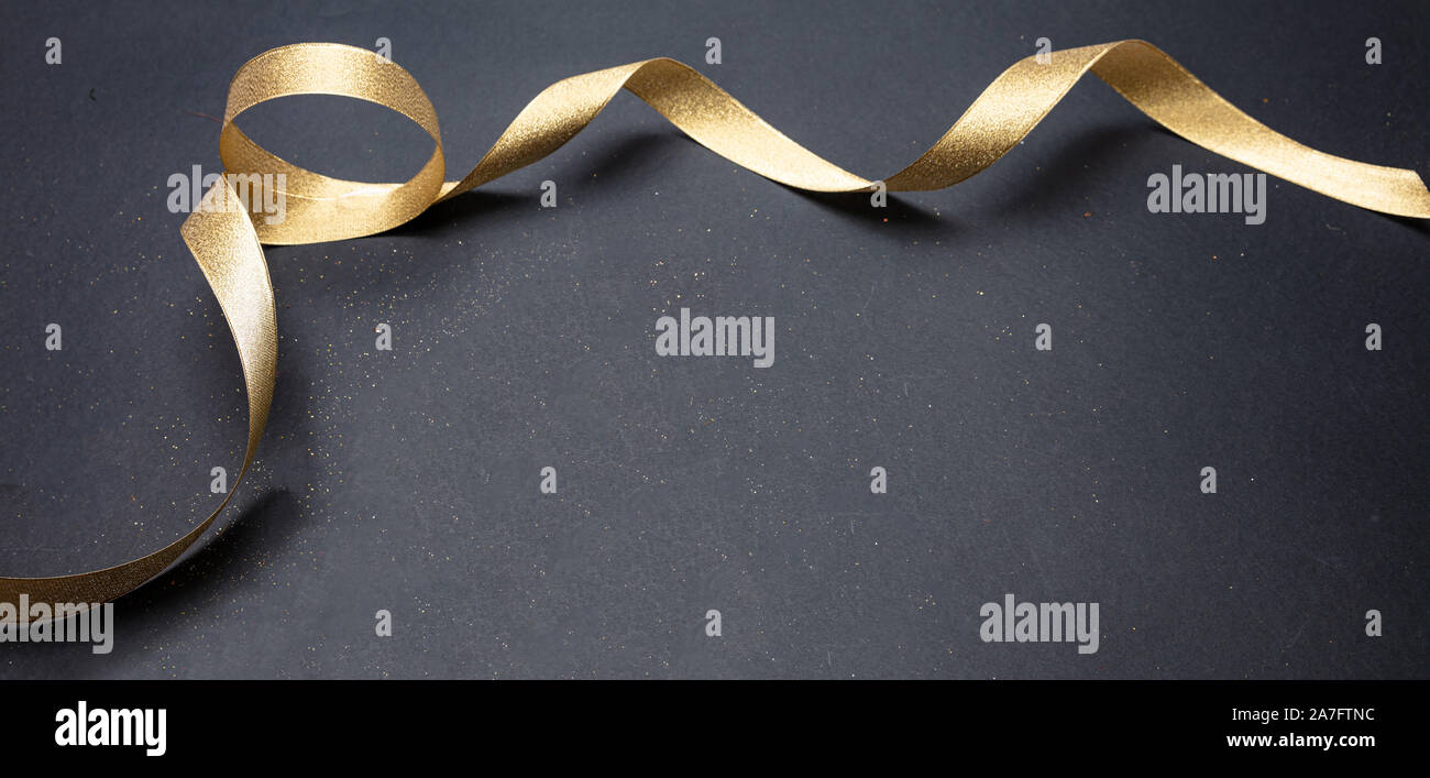 Christmas ribbon, gold shiny ribbon on black background, xmas ...