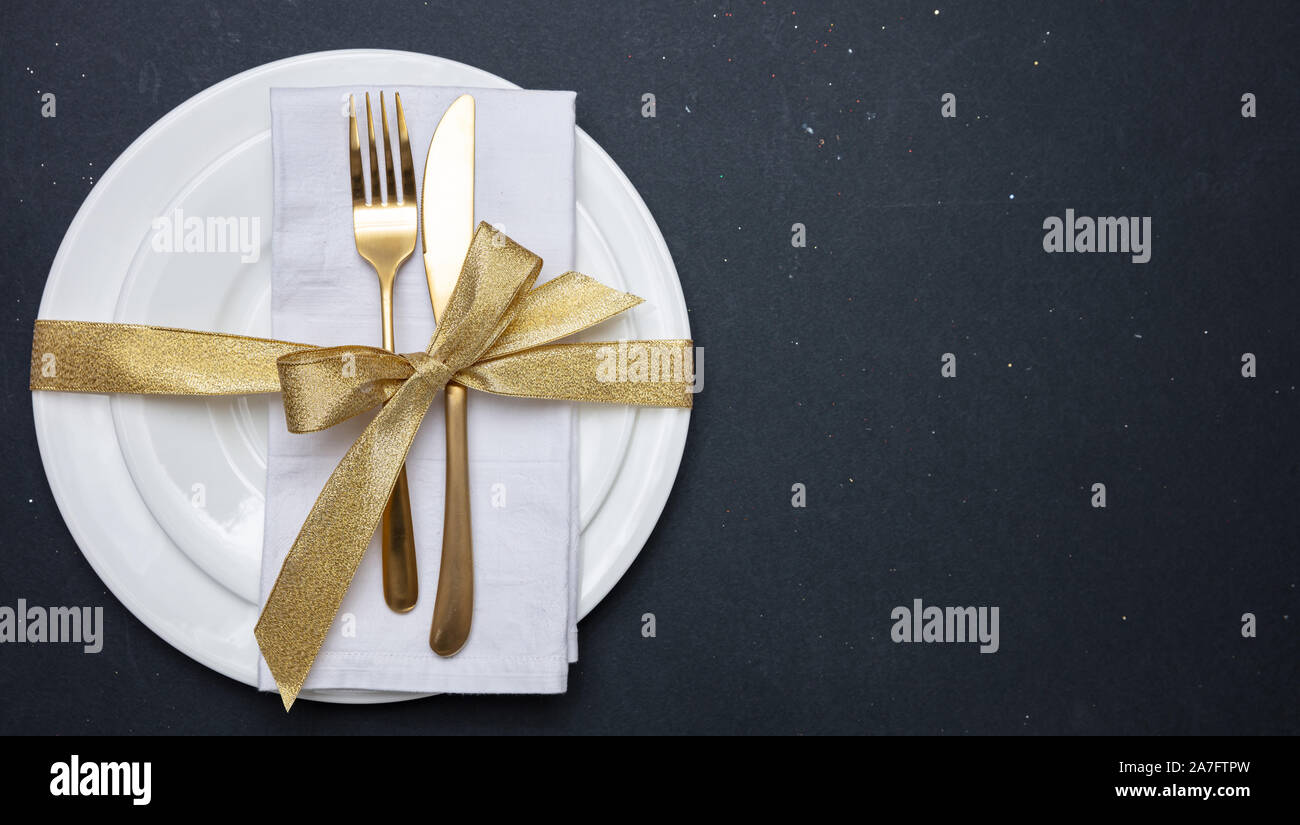 Table setting, luxury, formal. Gold cutlery on white set of dishes ...