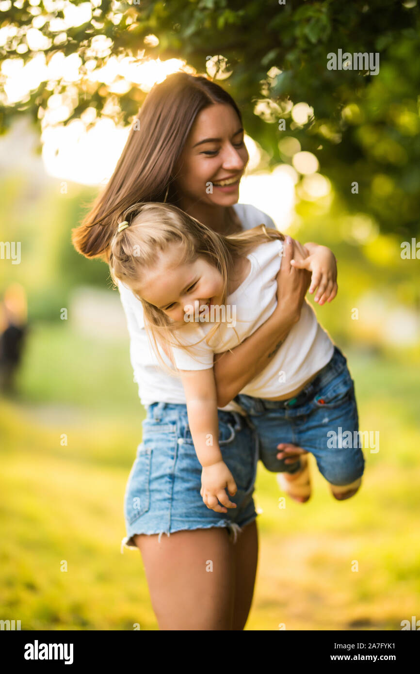 Mother and daughter playing circling around at the park on beautiful ...