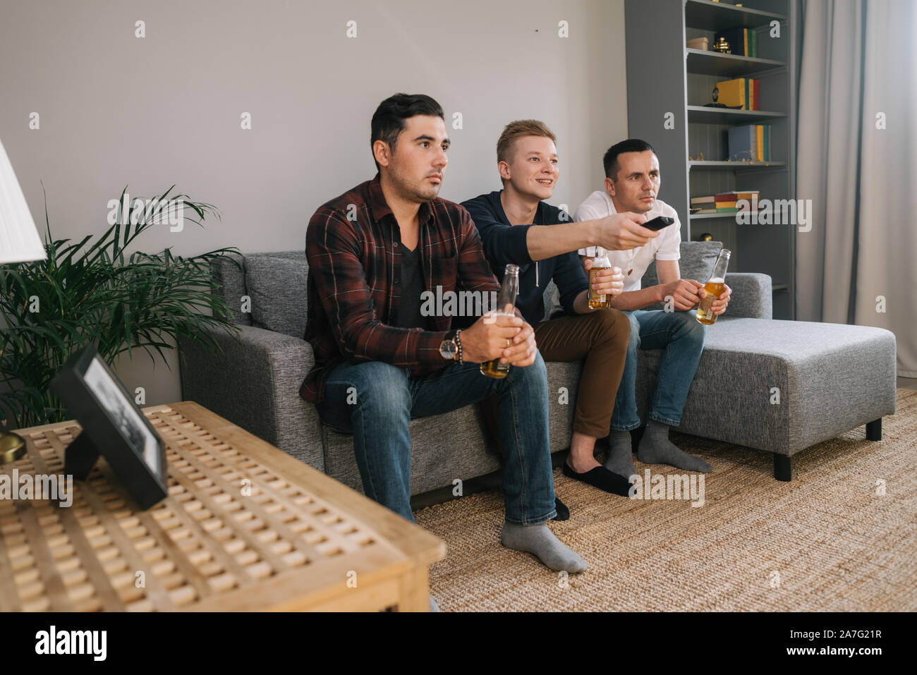 Young guy using remote control Stock Photo - Alamy