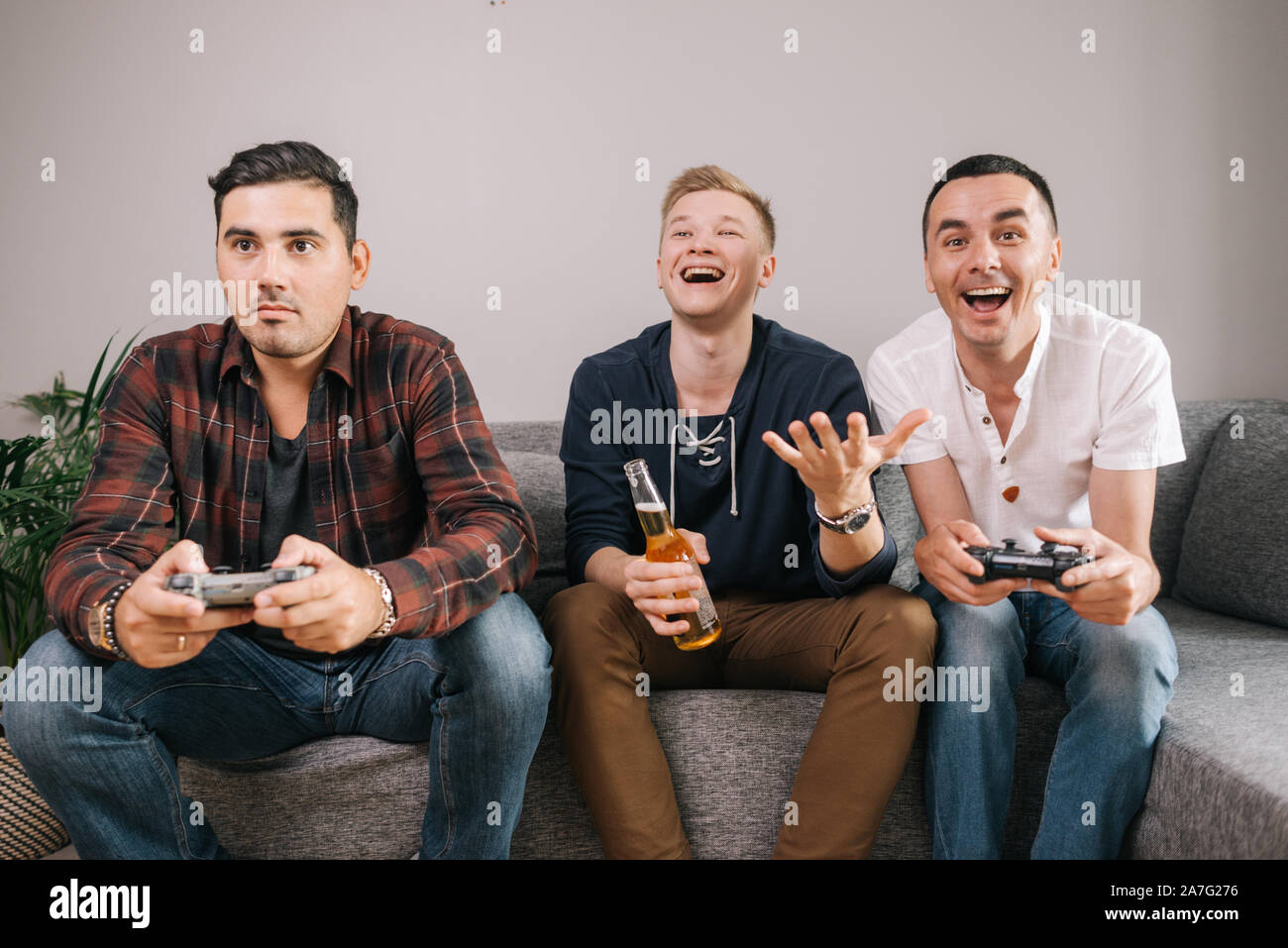 Joyful young men playing video game console Stock Photo - Alamy