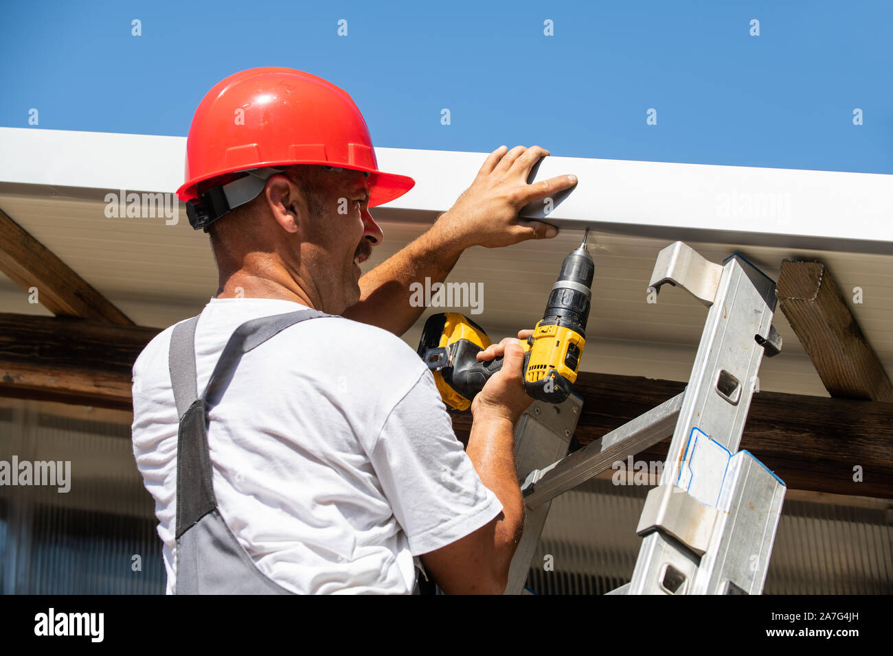 Roofer construction worker works in a construction site Stock Photo - Alamy