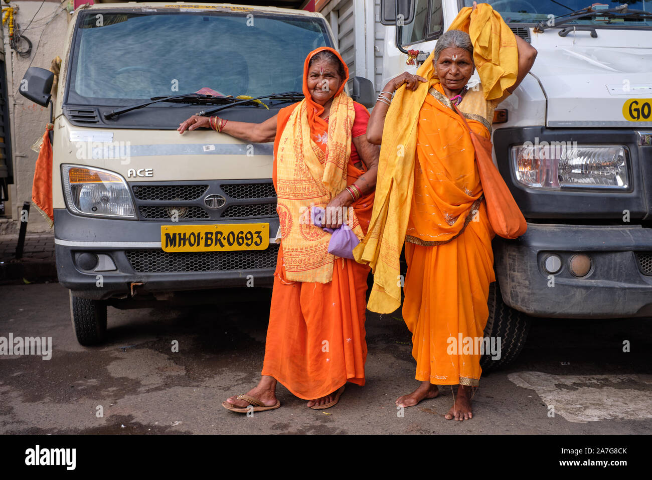 Two Indian sadhvis (female Hindu ascetics), clad in traditional orange ...