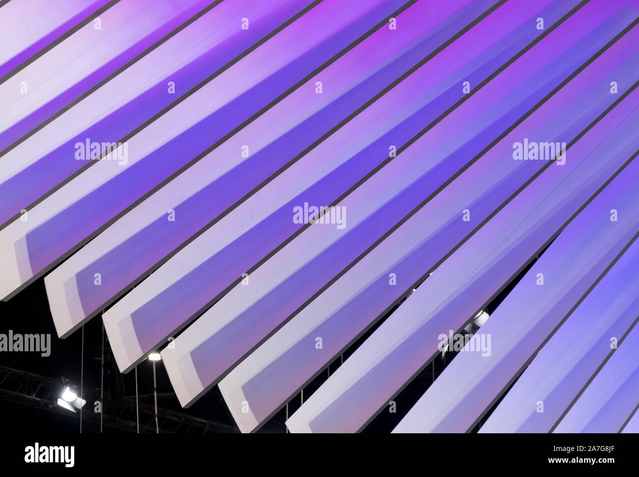 Curved plastic blade with the purple light is hanging on the ceiling of ...