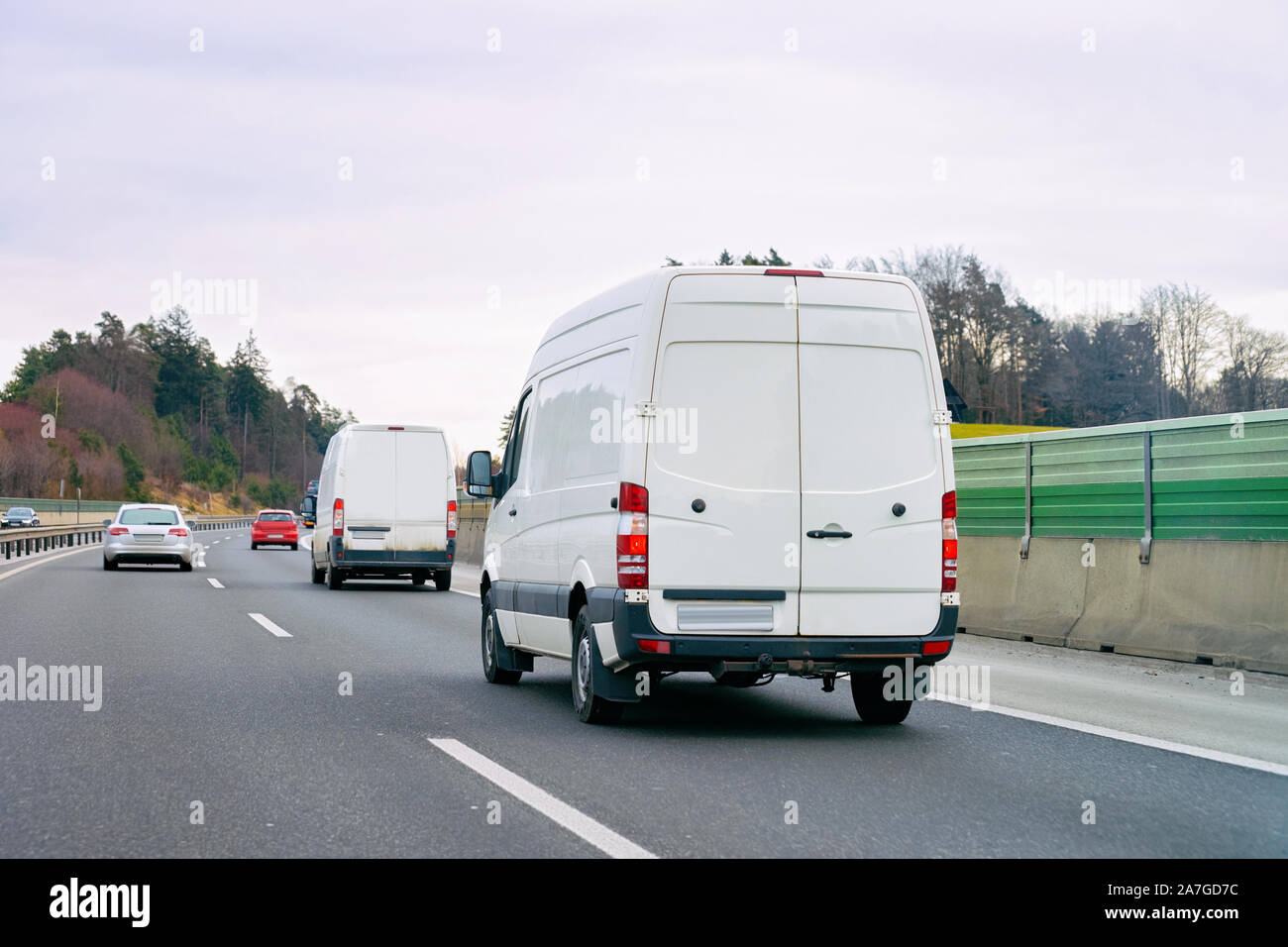 White Minivans in road European van transport Stock Photo - Alamy