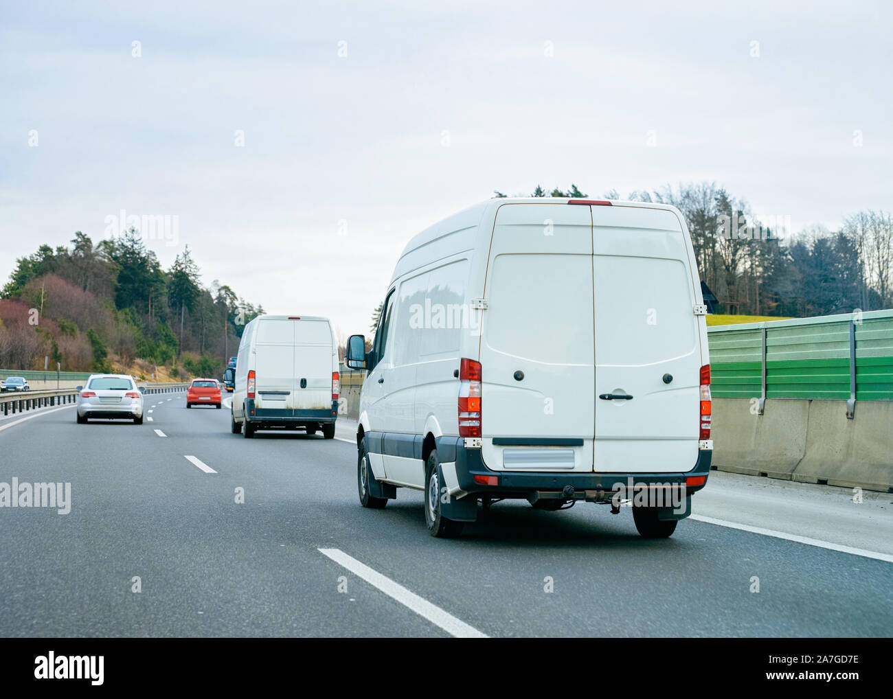 White Minivans on road van transport logistics Stock Photo - Alamy