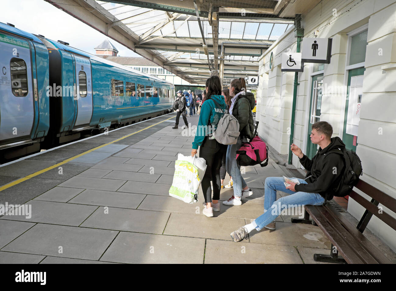 Young people women students with rucksacks and bags getting on ...