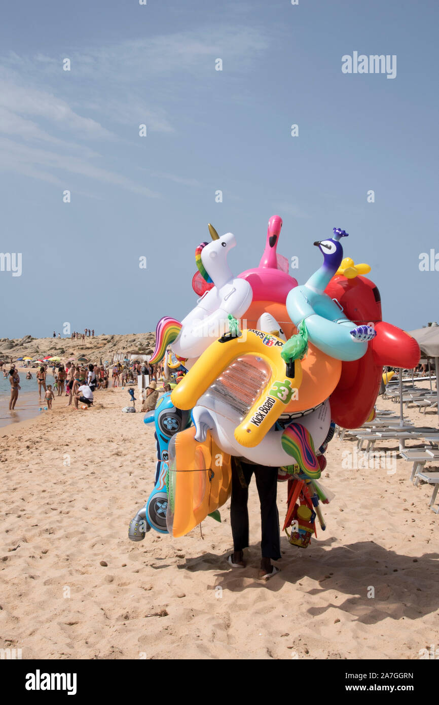 Overloaded Beach worker, Sardinia Stock Photo - Alamy