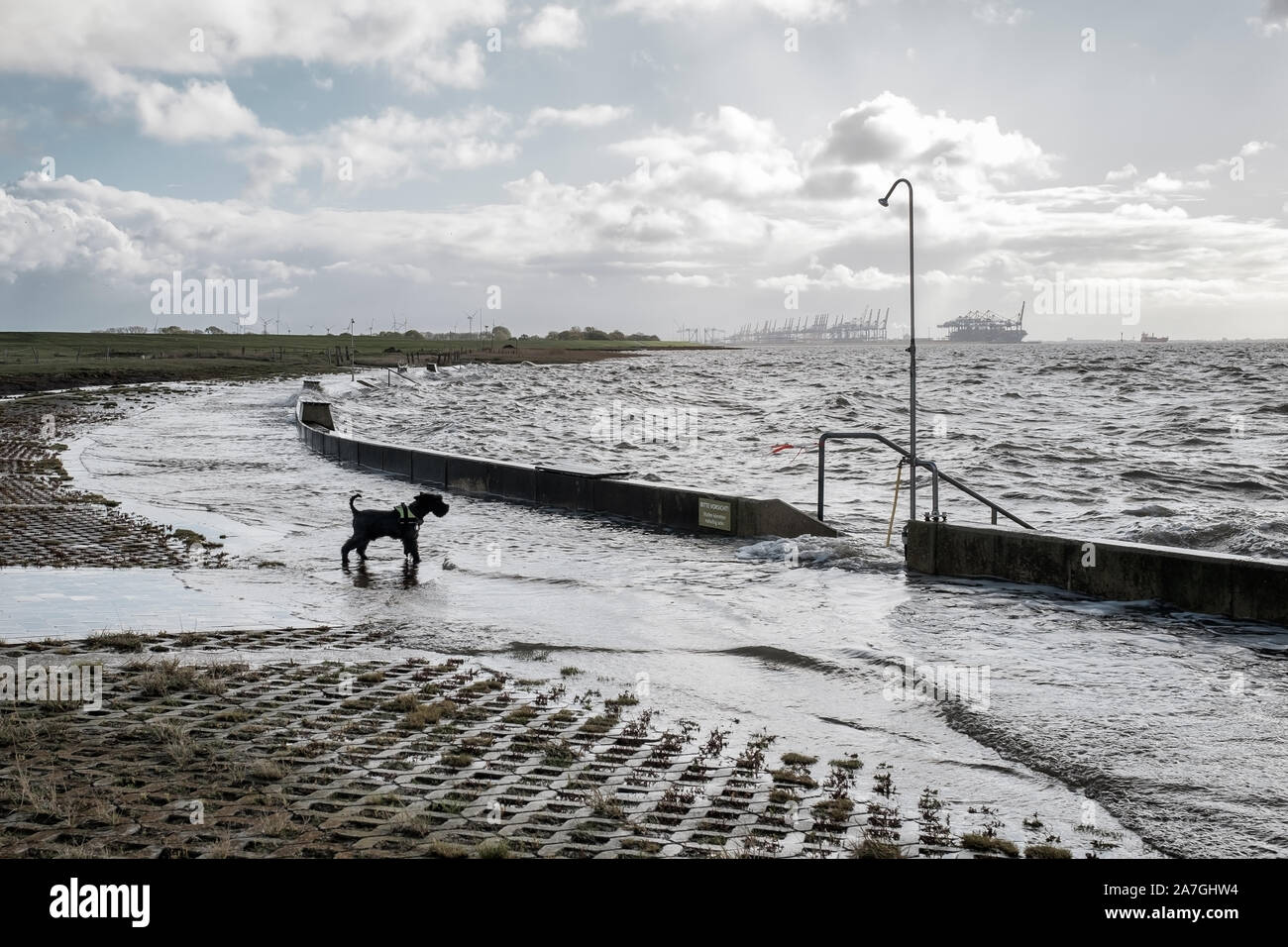 Splash of a wave on the flooded embankment near sea. It is written in ...