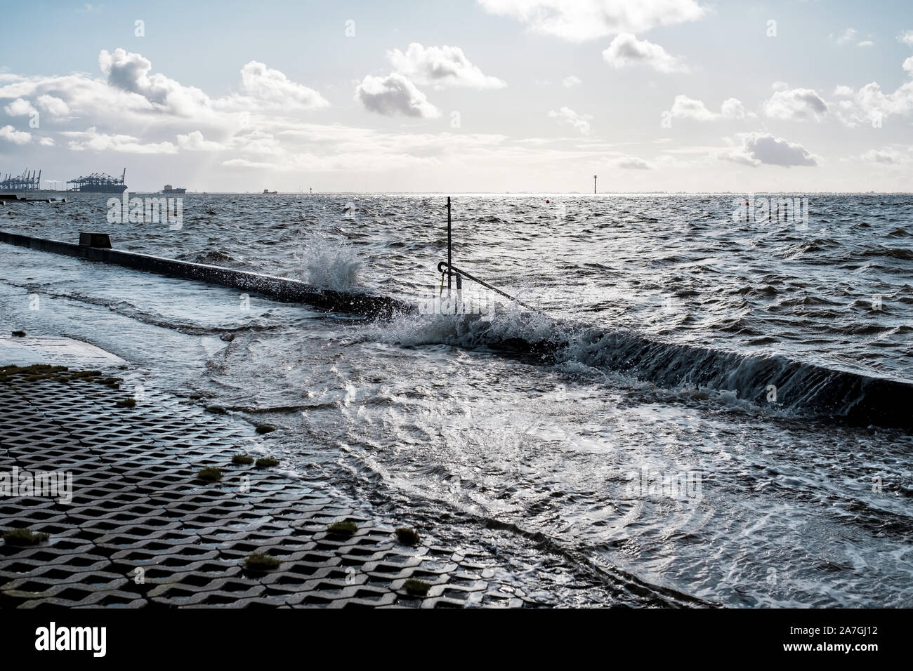 Splash of a wave on the flooded embankment near sea. It is written in ...