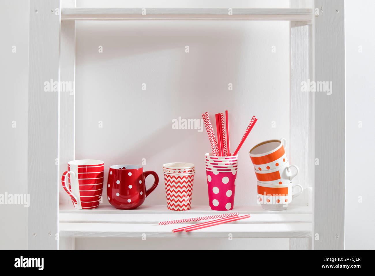 Different red mugs and glasses stand on a shelf in the kitchen Stock ...