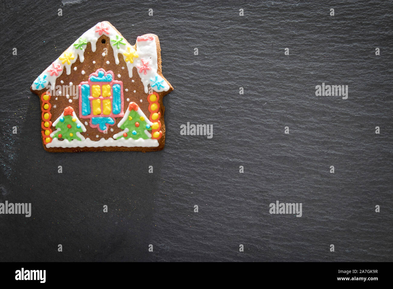 Gingerbread house with ornament on the black stone board ready to cook ...