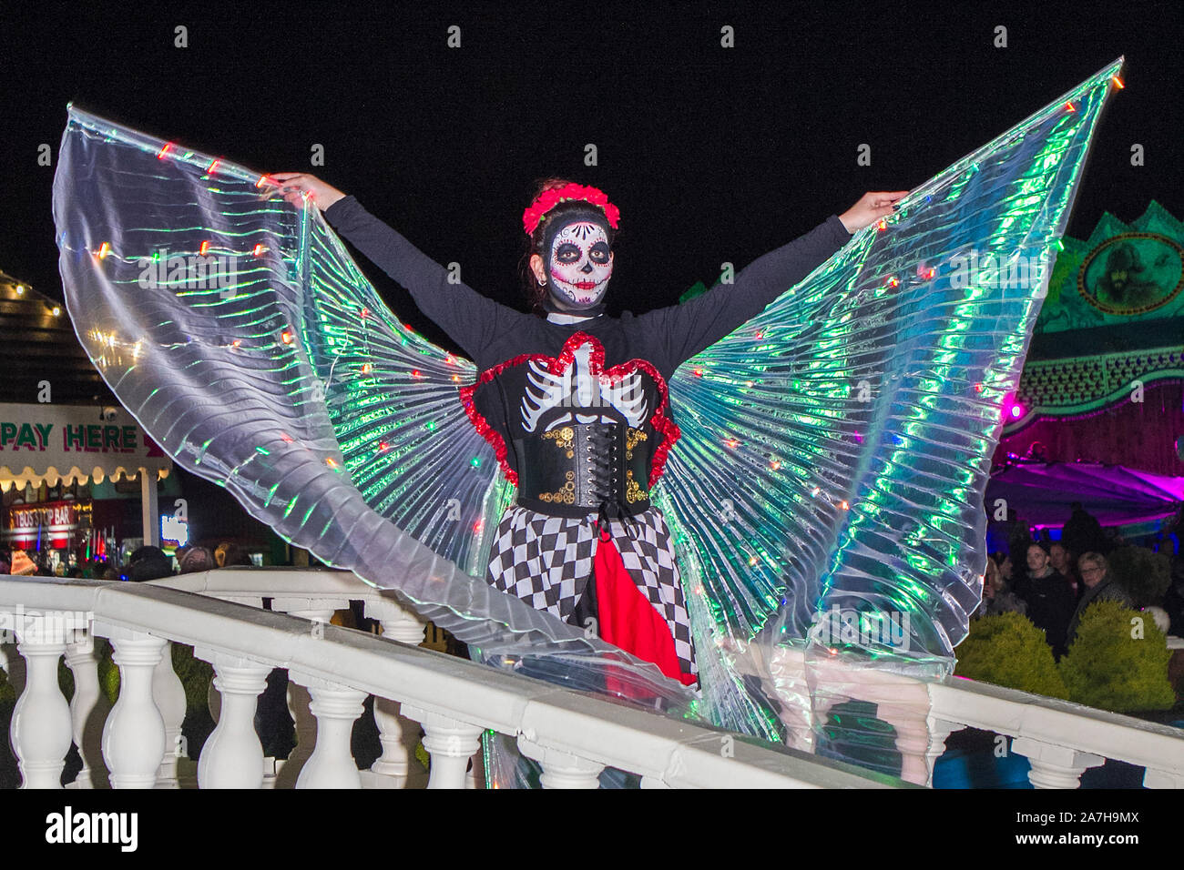 Illuminated sheer wings, swirling skirts, woman wearing white masked ...
