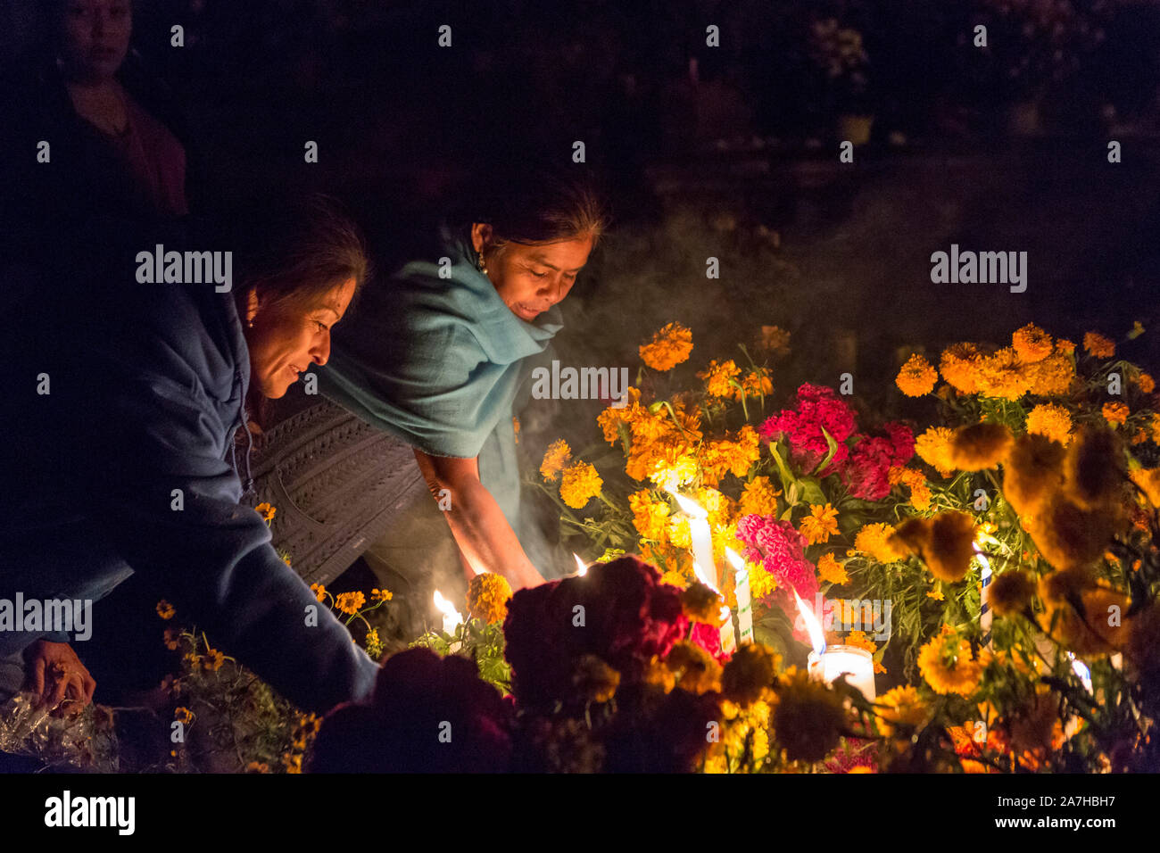 Family members light candles in honor of the dead at San Felipe de Aqua ...