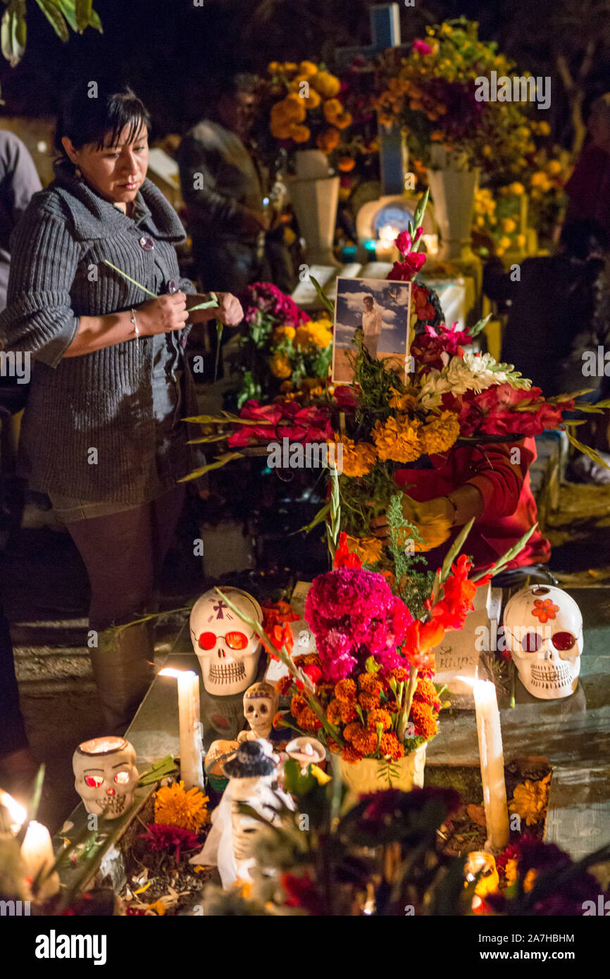 Family members light candles in honor of the dead at San Felipe de Aqua ...