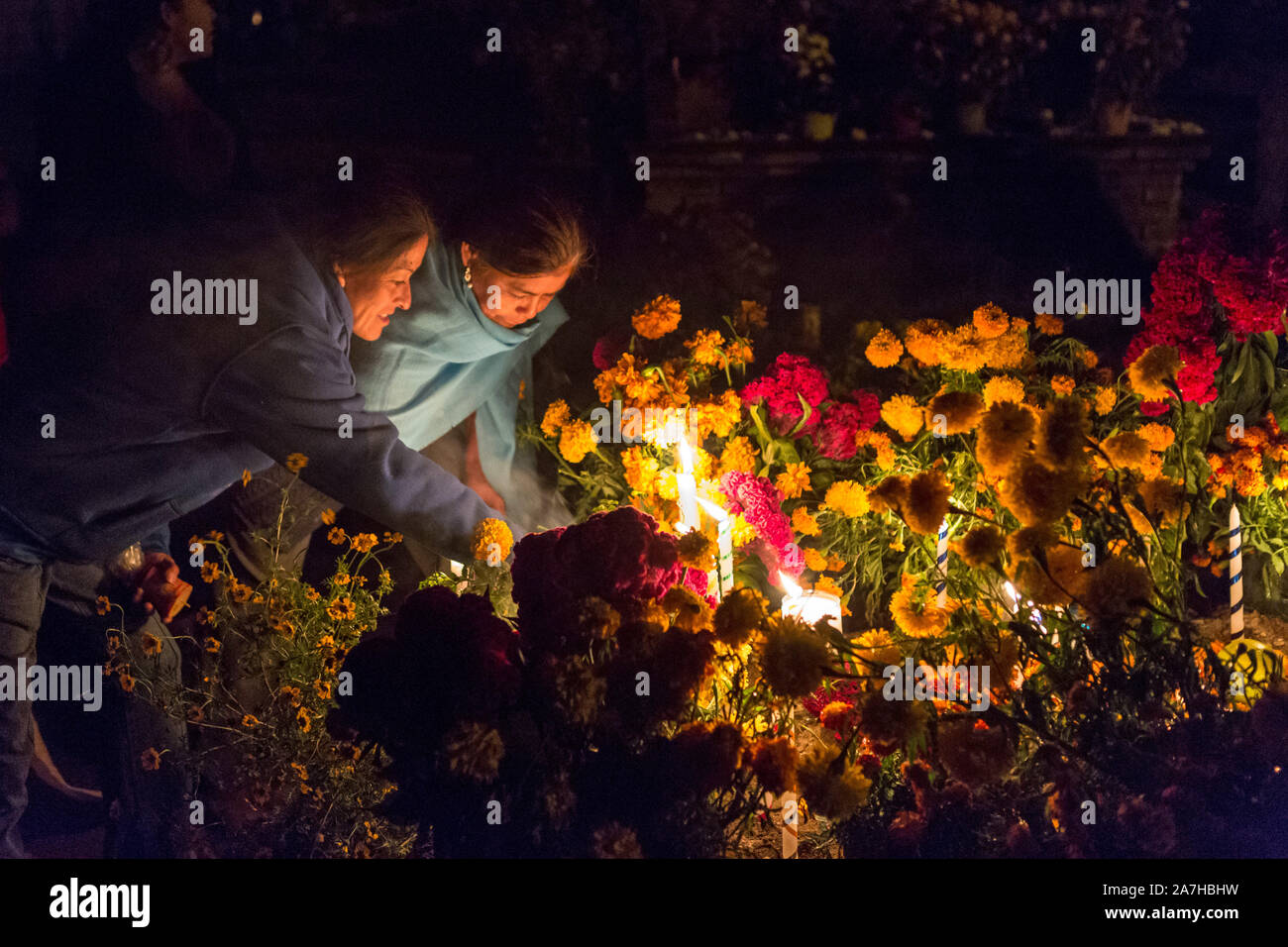 Family members light candles in honor of the dead at San Felipe de Aqua ...
