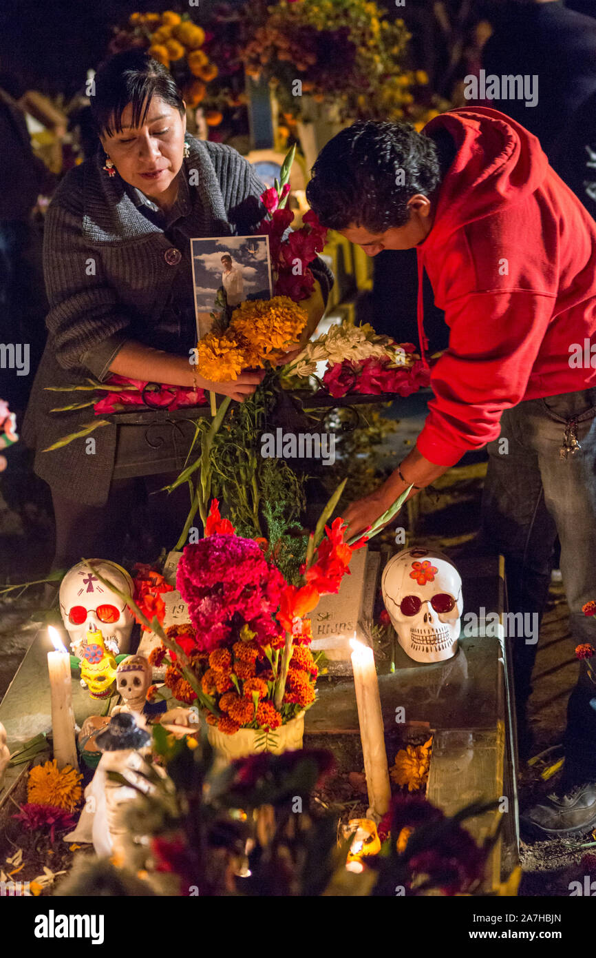 Family members light candles in honor of the dead at San Felipe de Aqua ...